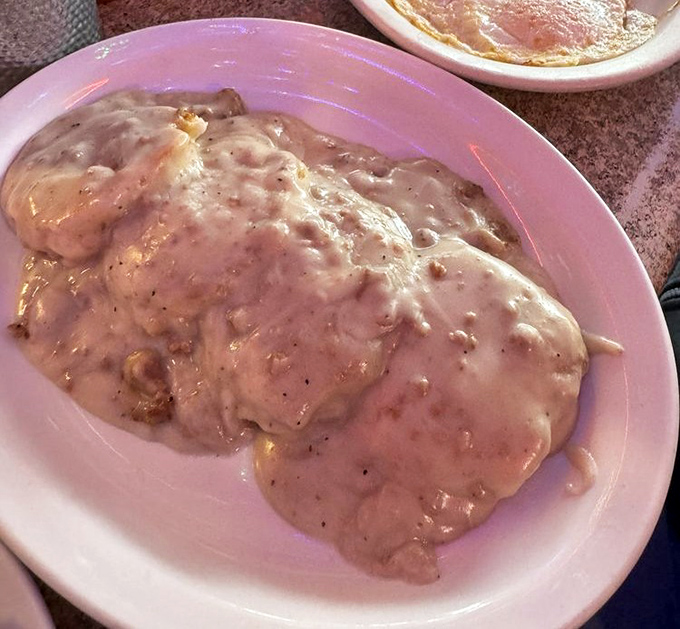 Biscuits and gravy that would make your Southern grandmother weep with joy, swimming in creamy, peppery goodness that demands to be savored.