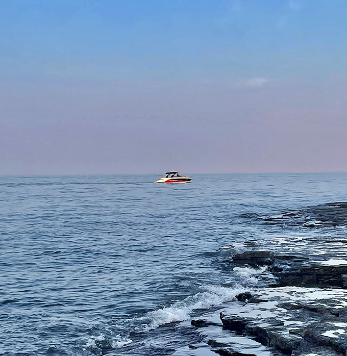 A boater's dream afternoon on Lake Erie's crystal waters, with the limestone shoreline creating nature's perfect frame.