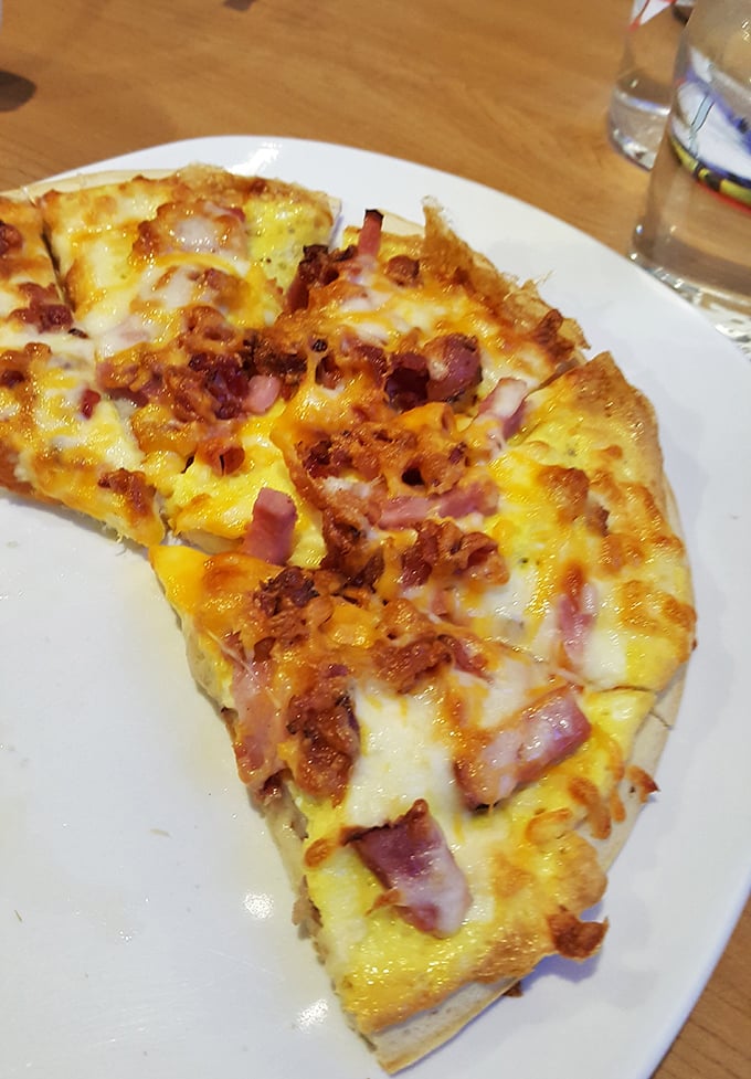 This breakfast pizza isn't just morning fuel – it's a crispy, cheesy reason to set your alarm early and beat the crowds.