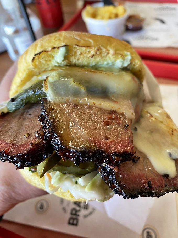 This isn't just a sandwich; it's brisket architecture&mdash;layers of smoky meat, pickles, and melty cheese creating the Taj Mahal of lunch options.
