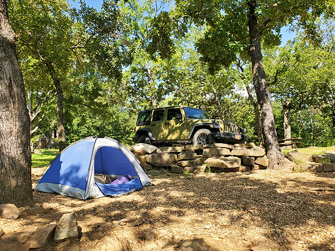 Camping perfection: blue tent, trusty Jeep, and trees that have witnessed more family vacations than a station wagon from the '70s.