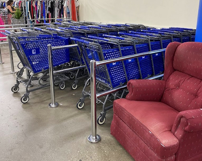 Blue shopping carts stand at attention beside a comfy red recliner&mdash;the thrifter's chariot awaits your bargain-hunting expedition.