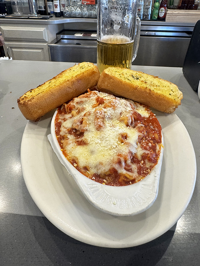 Garlic bread standing at attention beside a bubbling cavatini&mdash;like comfort food bodyguards protecting a treasure of cheese and sauce.