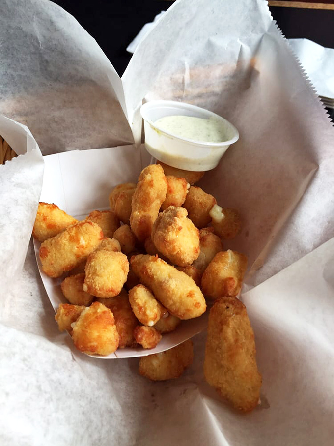 Wisconsin cheese curds &ndash; golden-battered nuggets of dairy perfection. The squeak might be silent, but your taste buds will be singing.