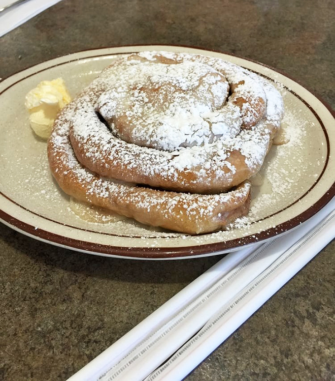 This cinnamon roll, dusted with powdered sugar, isn't just dessert disguised as breakfast &ndash; it's a religious experience on a plate.
