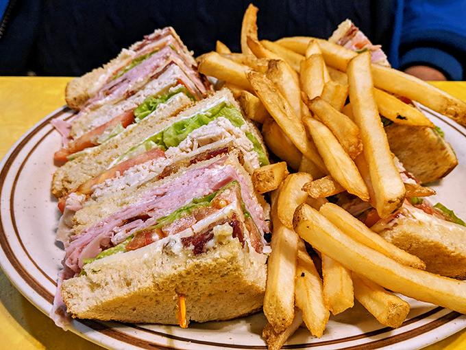 This club sandwich stands taller than some small-town water towers, with layers that tell a more compelling story than most Netflix documentaries.