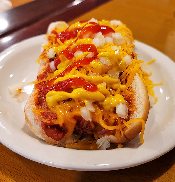 These coney dogs aren't just topped&mdash;they're architectural masterpieces of cheese, onions, and mustard that defy gravity and good manners.