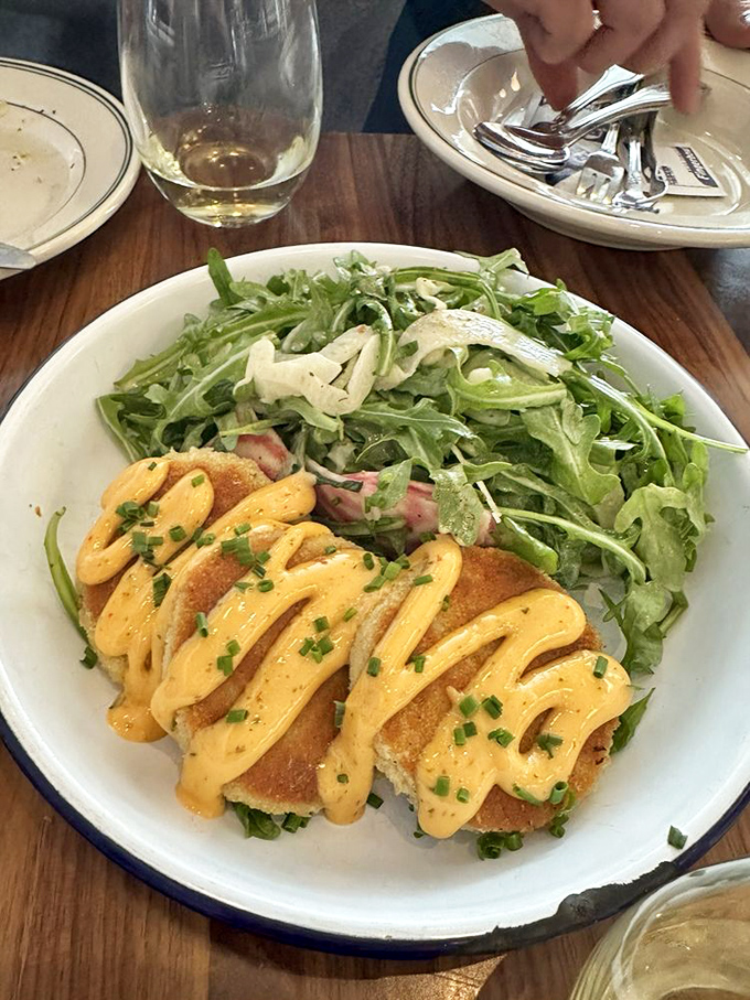 These crab cakes aren't playing around&mdash;golden-crisp exteriors giving way to sweet, delicate meat within. The sauce drizzle is just showing off.