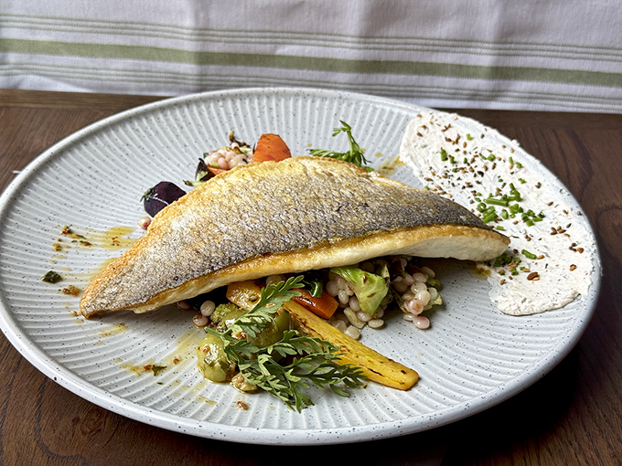 This crispy branzino perched atop colorful vegetables isn't just dinner&mdash;it's edible architecture that tastes even better than it looks.