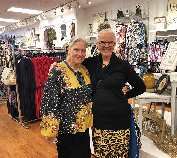 Two shoppers sharing that universal "I can't believe what I just scored" moment. The true magic of outlet shopping is having someone to high-five after finding that 70% discount.