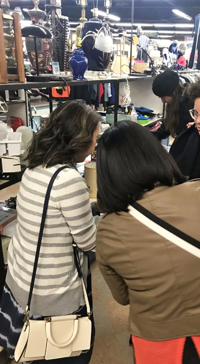 Shoppers examining treasures with the focused concentration of archaeologists unearthing artifacts from retail civilizations past.