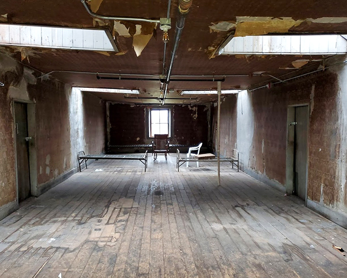 The dormitory ward—where dozens once slept under watchful eyes. Empty bed frames and peeling paint tell stories the occupants no longer can.