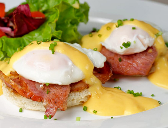 Eggs Benedict that would make a brunch snob weep with joy. That hollandaise sauce looks like liquid sunshine cascading over breakfast perfection.