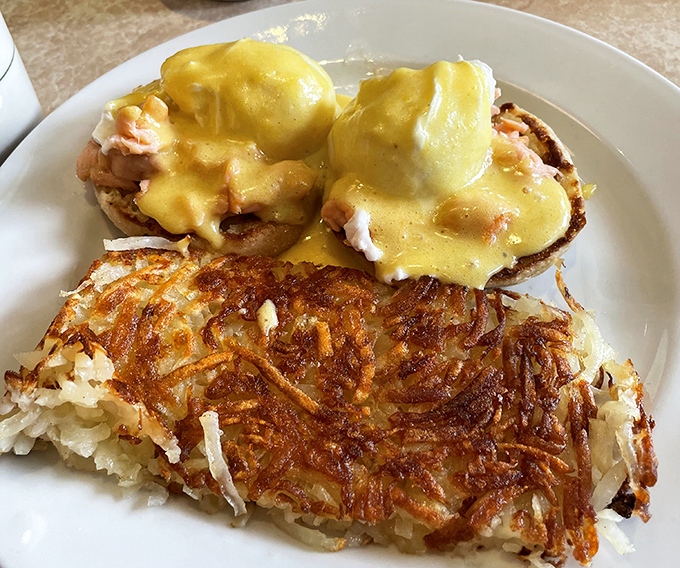 Eggs Benedict done right, with hollandaise sauce that cascades like golden silk over perfectly poached eggs.