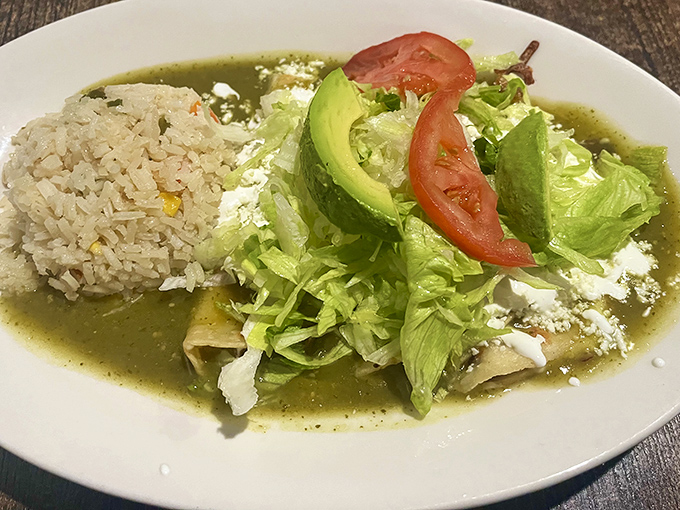 Enchiladas swimming in vibrant salsa verde with perfectly placed avocado slices. A dish that makes your fork the luckiest utensil at the table.