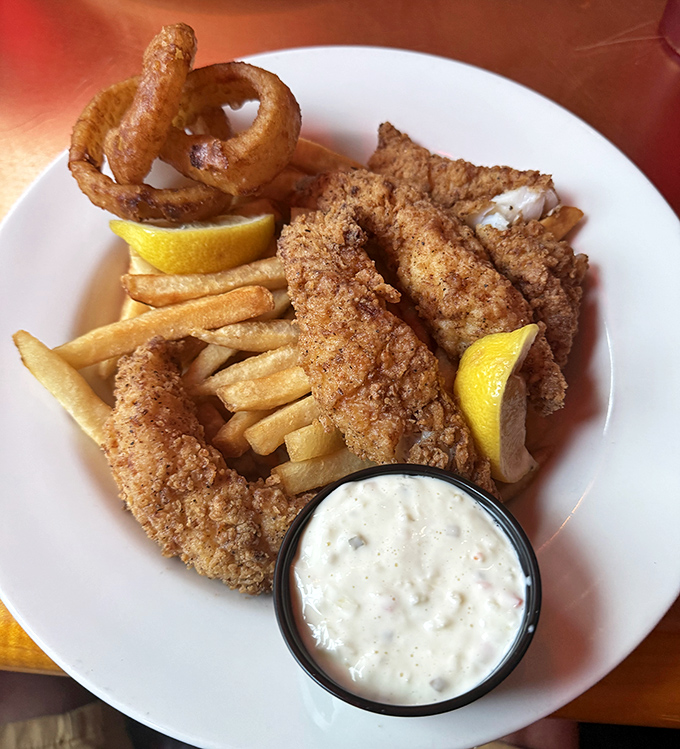 Golden-fried fish that shatters at first bite, paired with hand-cut fries and homemade tartar sauce—seafood simplicity that would make Neptune himself applaud.