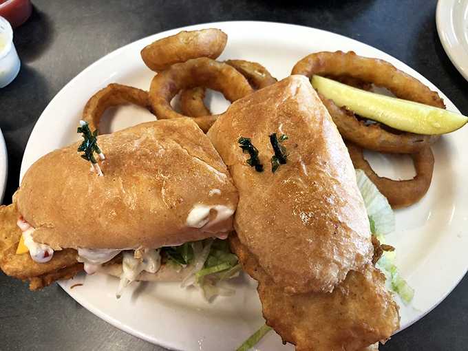 This isn&rsquo;t just a fish sandwich; it&rsquo;s architecture with flavor&mdash;golden-fried fillets nestled in a pillowy bun, with crispy onion rings standing guard.
