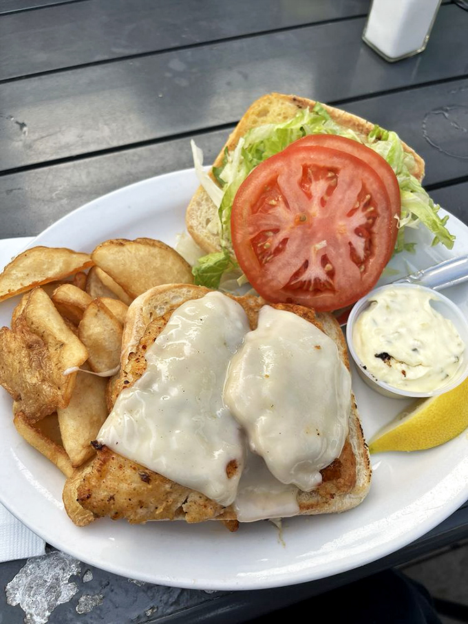 This isn't just a sandwich; it's seafood architecture. Melted cheese cascading over fish with house-made tartar sauce standing by for dipping duty.