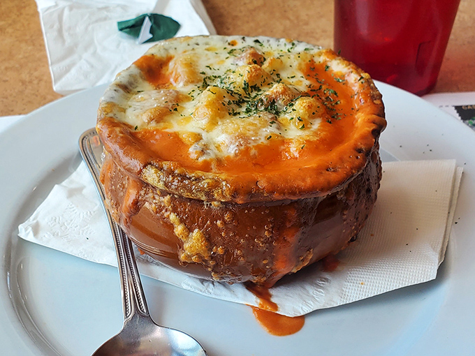 Not just soup, but a geological marvel—that molten cheese cap stretching skyward with each spoonful, hiding a savory broth that could cure whatever ails you.