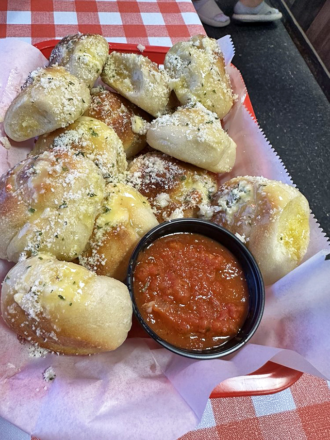 Garlic knots that could make a vampire reconsider their life choices. Pillowy dough puffs dusted with parmesan and served with marinara for essential dipping.