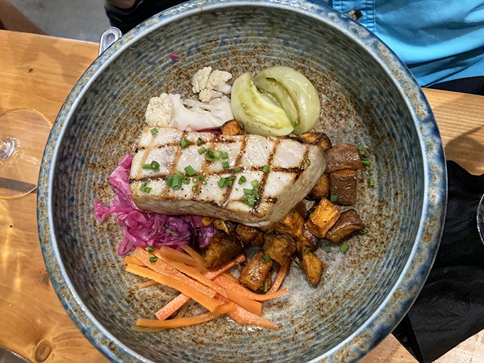 This isn't just grilled swordfish&mdash;it's a colorful maritime canvas. The perfectly charred fish rests atop a vibrant medley of roasted vegetables and pickled accents.