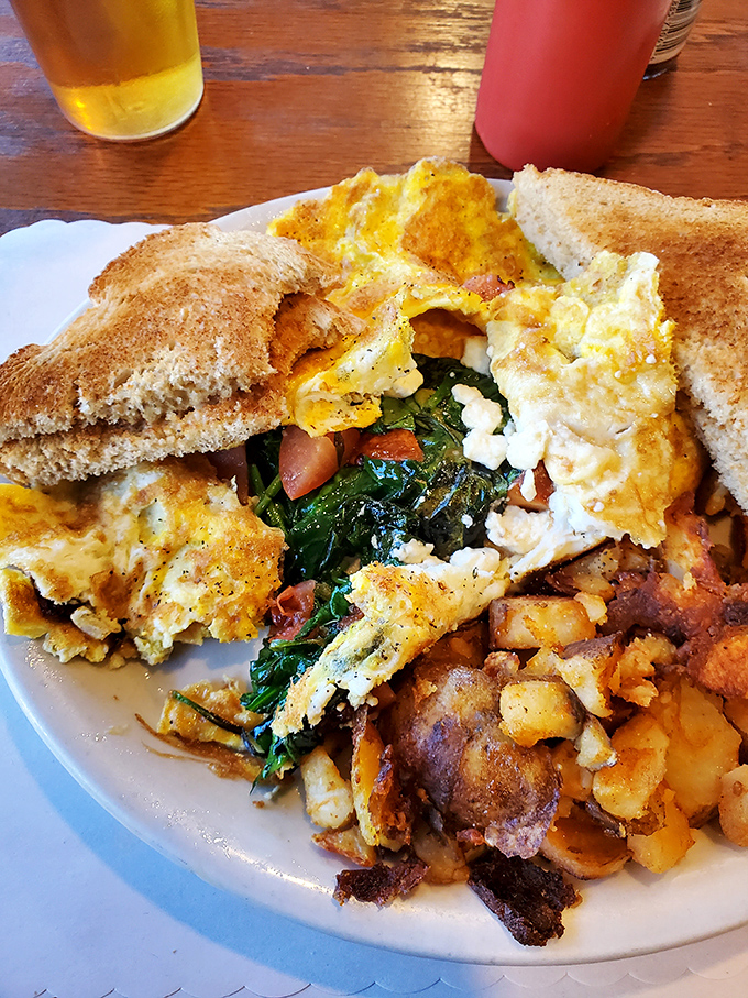 The holy trinity of breakfast: perfectly scrambled eggs, toast waiting for its butter baptism, and those legendary home fries that justify the journey.