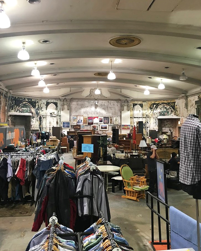 The vaulted ceilings and weathered walls tell stories of the building's past life, while racks of clothing hint at countless personal histories.