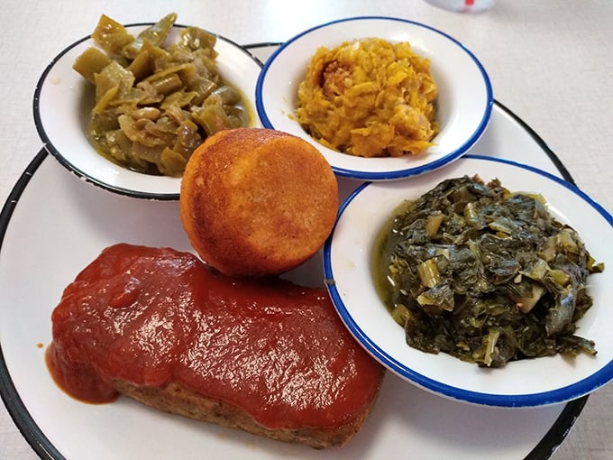 The holy trinity of Southern cooking: meatloaf bathed in tomato sauce, turnip greens swimming in pot liquor, and cornbread that deserves its own hymn.