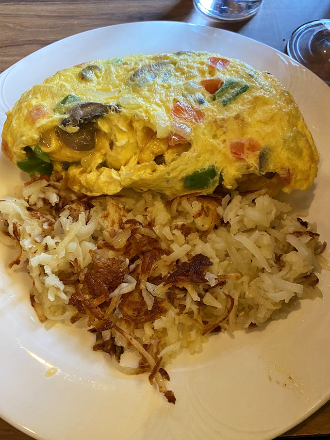 Breakfast magic happens when vegetables and cheese meet eggs. This omelet and those hash browns are the dynamic duo of morning satisfaction.