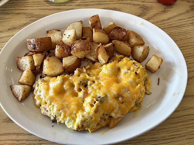 The omelet arrives like a golden sunrise next to perfectly crisped home fries&mdash;proof that simplicity, when executed perfectly, needs no embellishment.