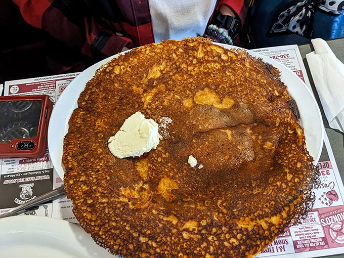 The pancake that launched a thousand road trips. Golden-brown, plate-sized, and sporting a perfect butter crown &ndash; breakfast royalty.