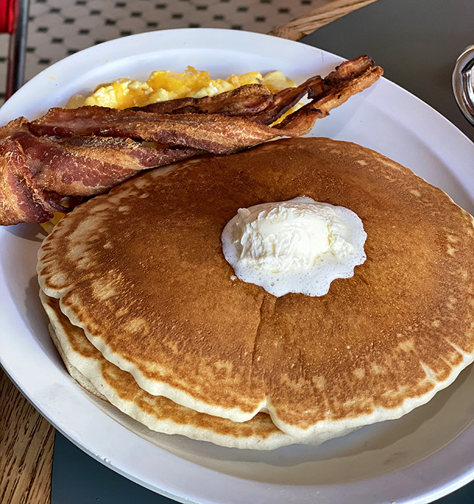 Pancakes so perfectly golden they deserve their own California vanity plate. That pat of butter melting center-stage is performing a slow, delicious disappearing act.
