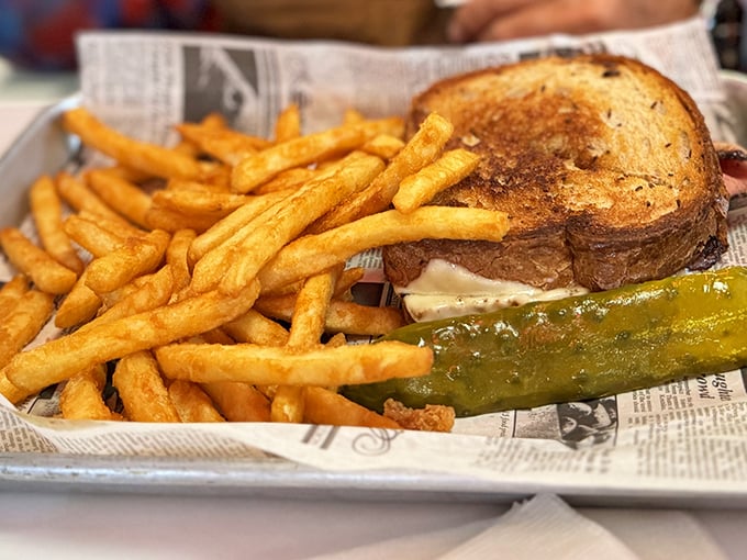 The patty melt arrives like a sandwich superhero&mdash;grilled rye bread cradling melted cheese and beef, with crispy fries standing guard on newspaper.