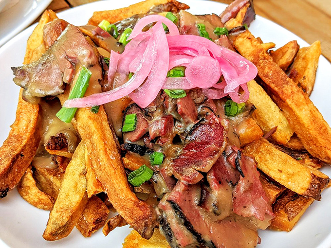 Loaded fries that blur the line between side dish and main event, topped with tender smoked meat and pickled onions that cut through the richness.