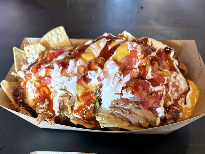 Pulled pork nachos: where tortilla chips fulfill their destiny as vehicles for smoky meat, melty cheese, and that zigzag of sauce that says "someone cares."