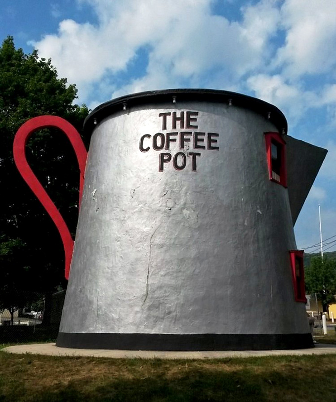That magnificent red handle isn't just for show&mdash;it's architectural whimsy at its finest, curving dramatically against the silver pot like a sculptural exclamation point.