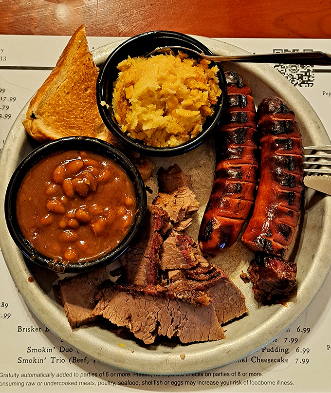 This plate tells a story of patience&mdash;sliced brisket with that telltale pink smoke ring, sausage with perfect snap, and sides that refuse to be mere afterthoughts.