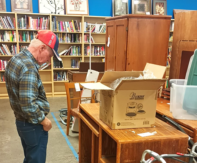 A shopper examines furniture possibilities with the focused concentration of a chess grandmaster planning their next three moves.