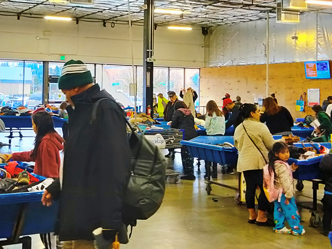 The weekend rush at Goodwill resembles a friendly archaeological dig, with shoppers carefully sifting through bins for that perfect find.