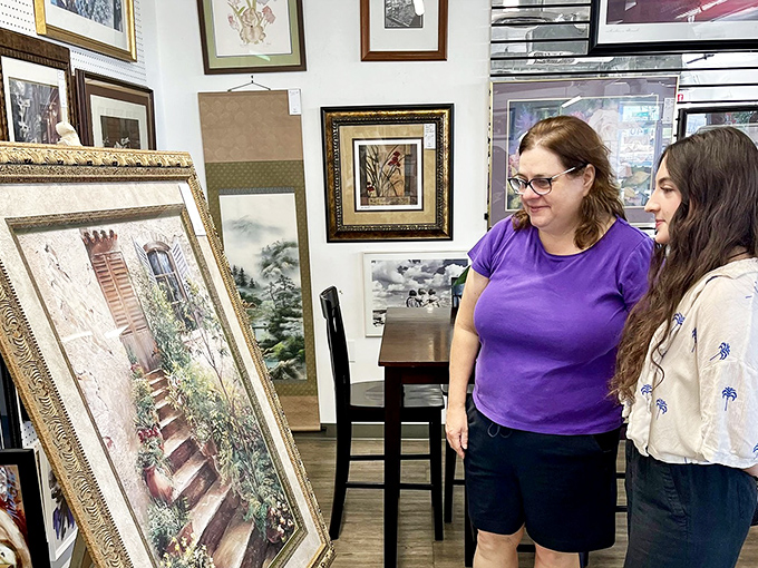 The thrill of the hunt captured in real time. These treasure seekers evaluate a potential masterpiece for their home, proving art appreciation doesn't require a gallery membership.