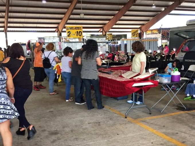 The universal language of flea market negotiation in action. Notice the focused expressions&mdash;these shoppers aren't just browsing, they're on a mission.