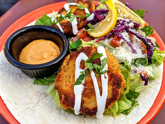 The legendary crab cake in its natural habitat&mdash;surrounded by fresh greens and drizzled with sauce that should be bottled and sold as liquid happiness.