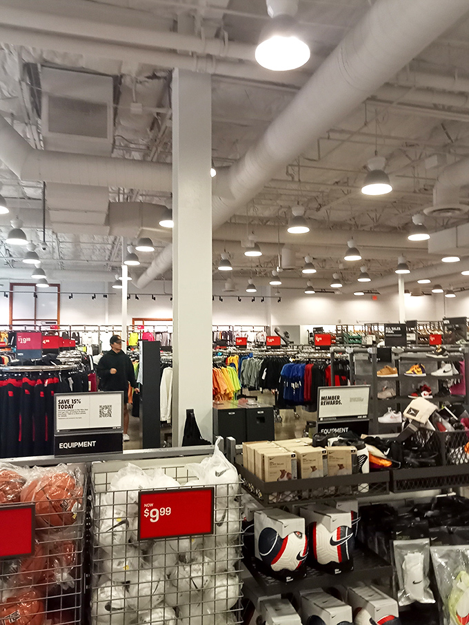 Inside the Nike Factory Store, where athletic dreams and budget realities find their happy compromise. Treasure hunters navigate racks of discounted sportswear like seasoned explorers.