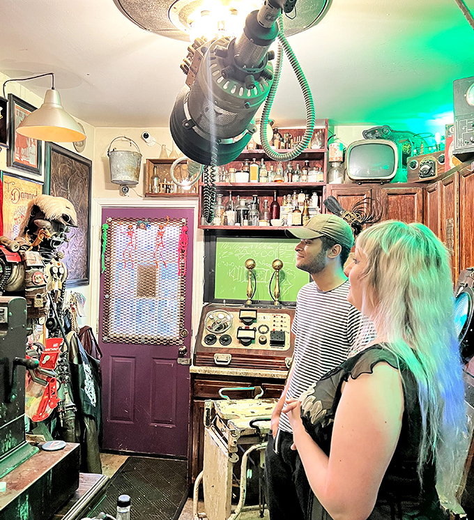 Visitors stand transfixed by the otherworldly collection, bathed in an eerie green glow that adds to the delightful discomfort.