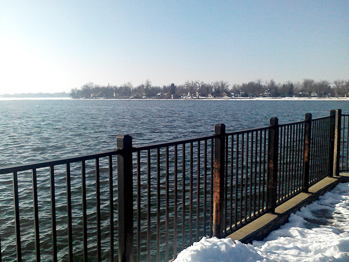 Lake Okabena in winter reveals its stoic beauty, where ice-trimmed shores and crisp horizons create a meditation space for hardy Minnesotans.