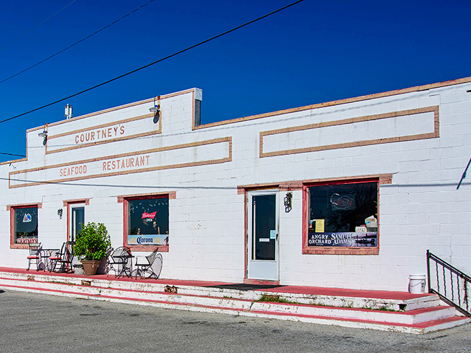 Courtney's white building with red trim stands like a culinary lighthouse, guiding hungry travelers to seafood salvation.