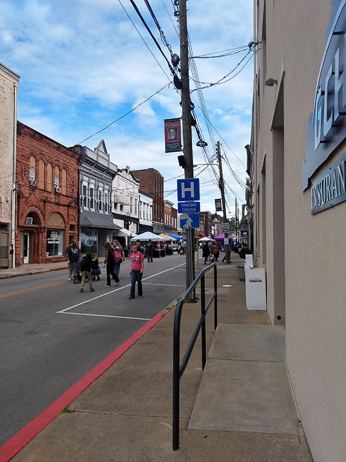 Market day madness! Cynthiana's brick-lined thoroughfare buzzes with pedestrians beneath a tangle of power lines, like a small-town version of "Breakfast at Tiffany's" street scene.