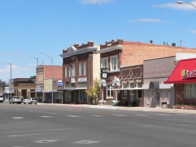 Two-story brick buildings with ornate cornices create a stately main street under brilliant blue skies.