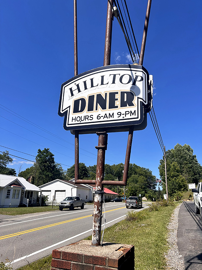 Hilltop Diner's sign stands tall against the blue West Virginia sky. Hours posted like a promise: 6AM-9PM, we've got you covered.