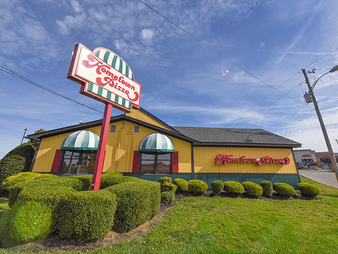 Hometown Pizza's cheerful yellow building with green-striped awnings looks like the pizza equivalent of a summer day.